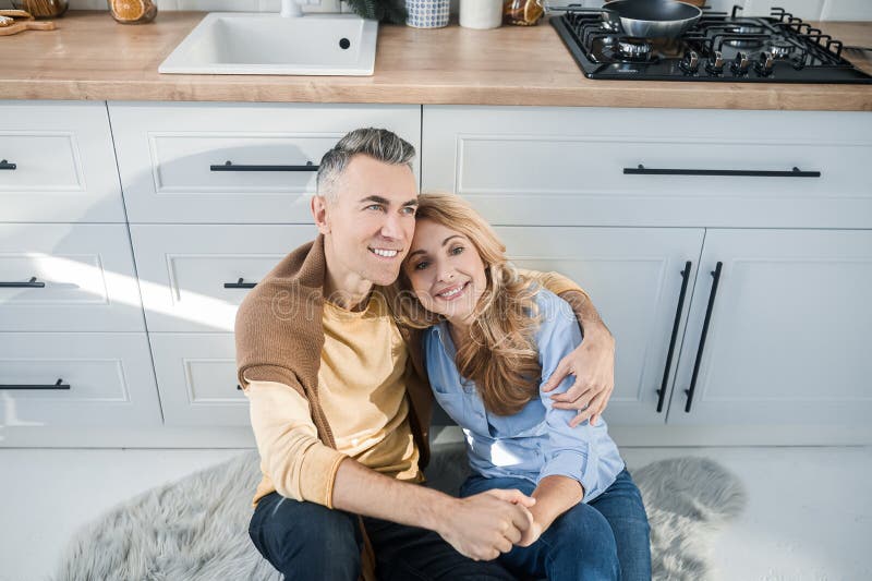 A Happy Couple Sitting in the Kitchen and Looking Joyful Stock Image ...