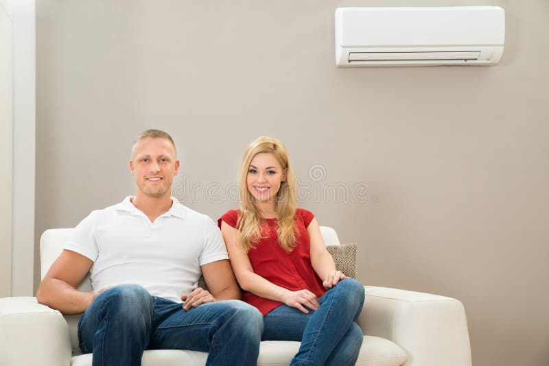 Happy Couple Sitting on Sofa Stock Image - Image of conditioning, home ...