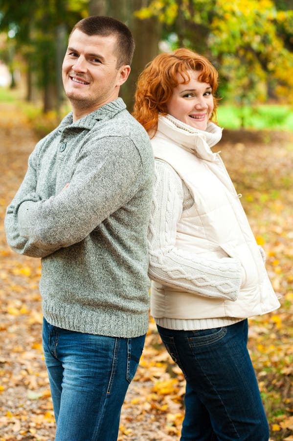 Happy Couple Standing Back To Back Stock Photo - Image of redhead ...