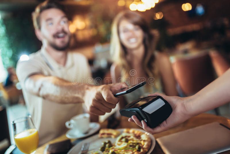 Couple Using Mobile Phone and Making Contactless Payment in a ...