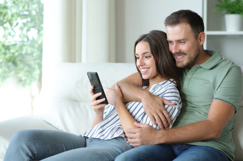 Happy Couple Using Mobile Phone Together at Home Stock Image - Image of ...