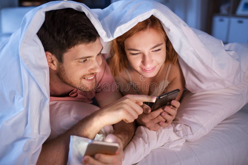 Happy Couple Using Smartphones in Bed at Night Stock Image - Image of ...