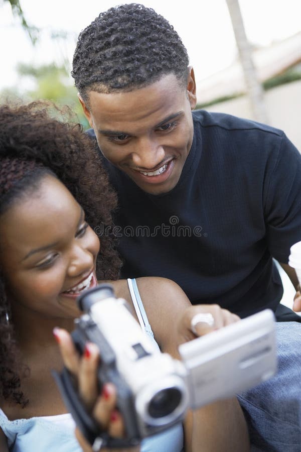 Happy Couple Watching a Camcorder Stock Photo - Image of smile, couple ...