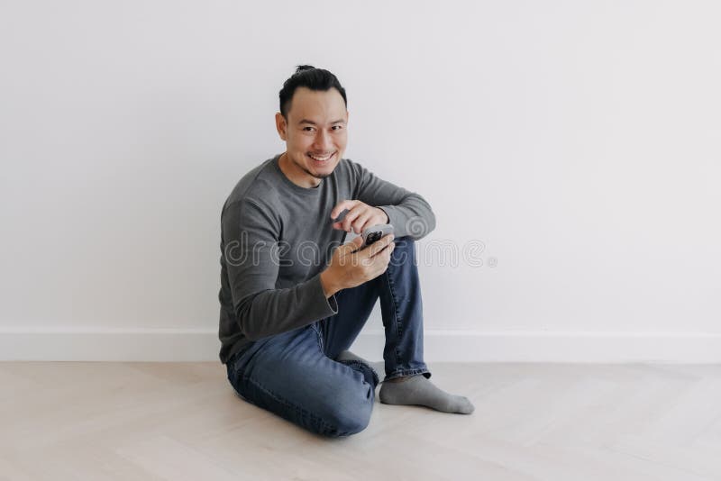 Happy Creative Freelance Man Sitting on the Floor Using His Phone ...