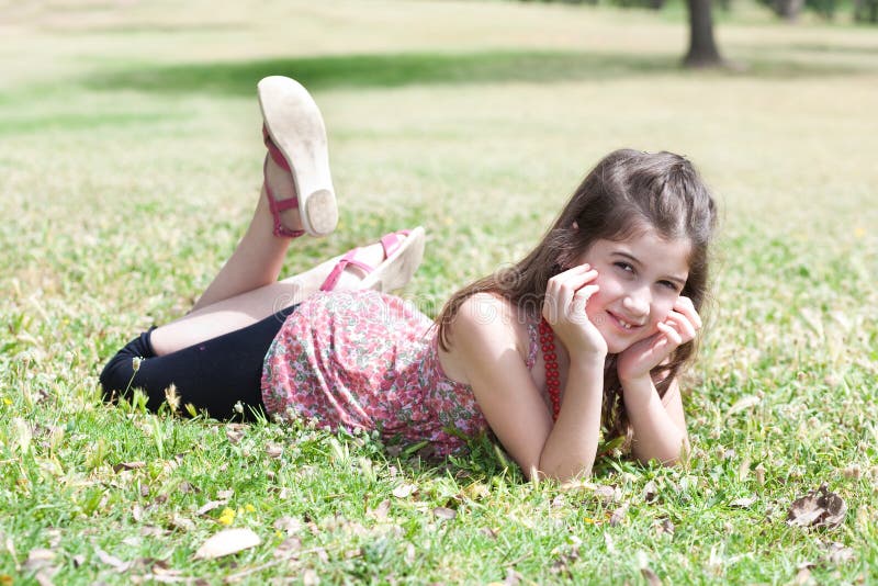 Happy Cute Girl Laying on a Grass Field Stock Photo - Image of outdoors ...
