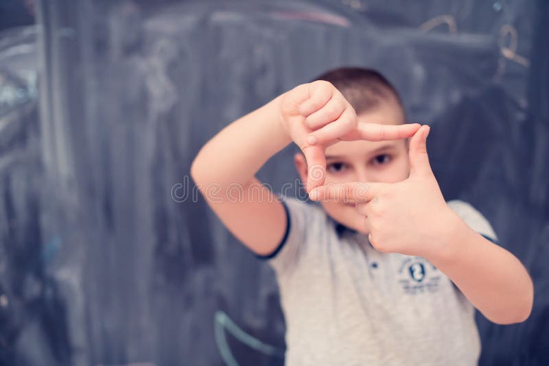Happy Boy Making Hand Frame Gesture in Front of Chalkboard Stock Image ...