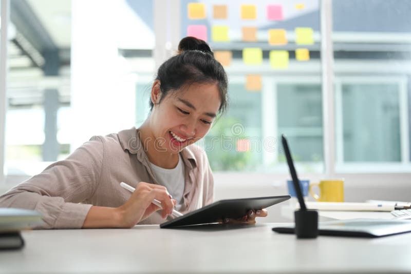 A Designer Working on Digital Tablet at Her Desk in Creative Office ...