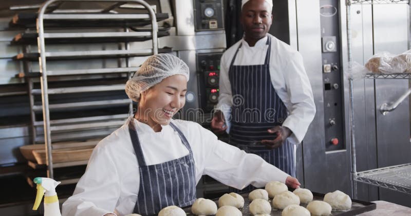 Happy Diverse Bakers Working in Bakery Kitchen, Holding Baking Sheet ...