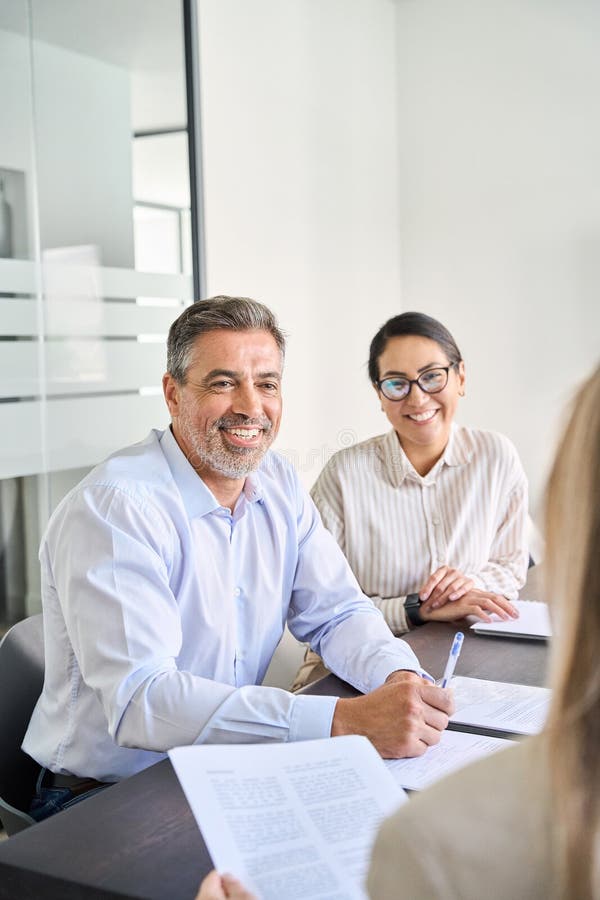 Two Happy Diverse Workers Talking Standing in Office. Vertical Shot ... Two Happy Diverse Workers Talking Standing in Office. Vertical Shot ...