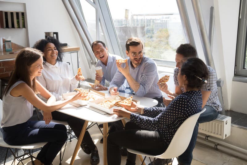 Happy Diverse Colleagues Eating Pizza During Office Work Break Stock