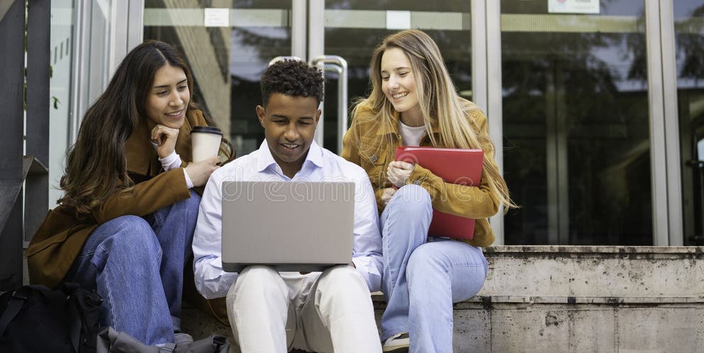 Happy Diverse College Students Collaborating on a Project Using Laptop ...