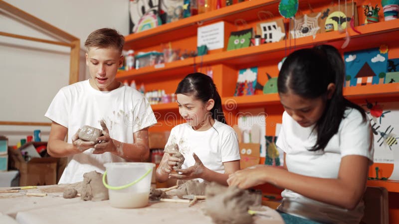 Happy Diverse High School Student Modeling Clay at Pottery Workshop ...