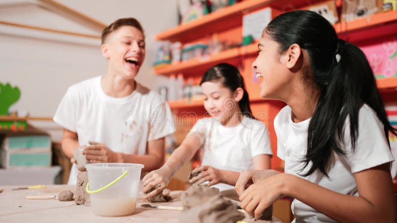 Happy Diverse High School Student Modeling Clay at Pottery Workshop ...