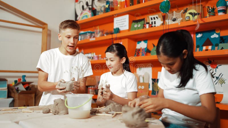 Happy Diverse Highschool Student Modeling Clay at Pottery Workshop ...