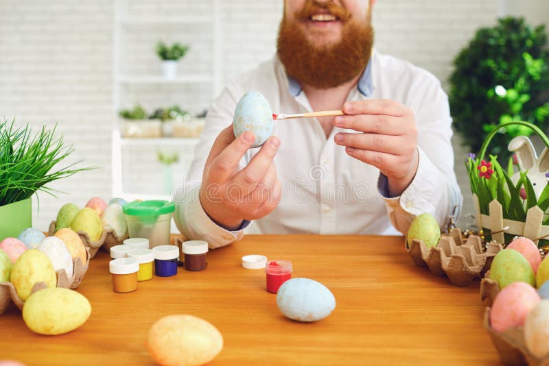 Happy Easter. the Hands of a Bearded Fat Man Decorate Eggs at a Table ...