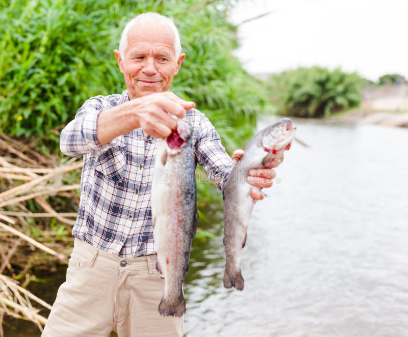 Fisherman Posing with Catch at Riverside Stock Photo - Image of fish ...