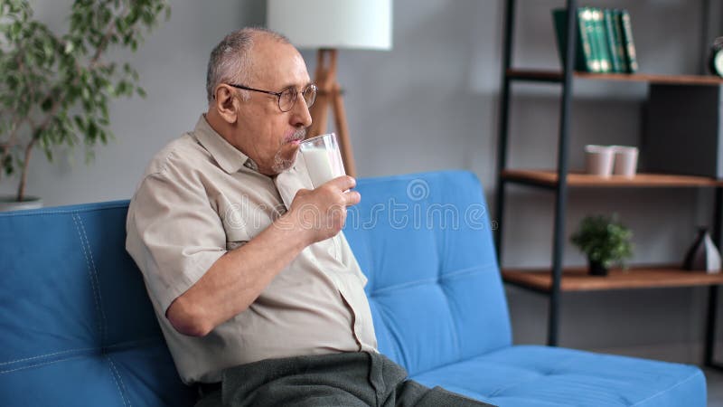 Happy Elderly Man Drinking Fresh Milk Glass Sitting On Comfortable
