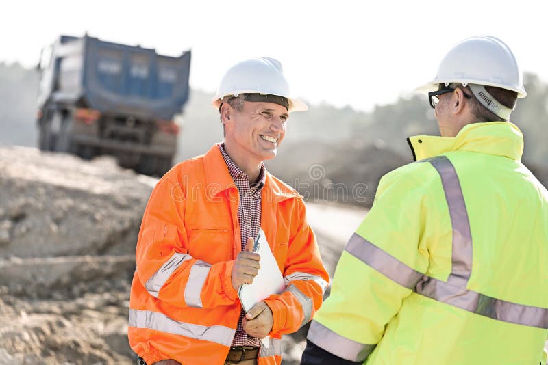 Happy Engineer Discussing with Colleague at Construction Site on Sunny ...