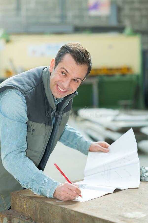 Happy Engineer with Plan Looking at Blueprint Stock Photo - Image of ...