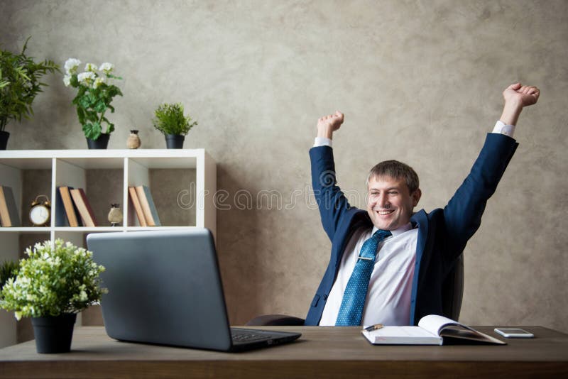 Happy Excited Young Businessman Sitting On Workplace And Celebrating
