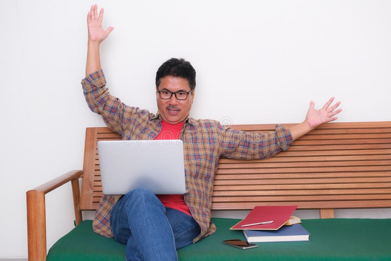 Happy Expression of Man Sitting on Sofa, Working on His Laptop from ...