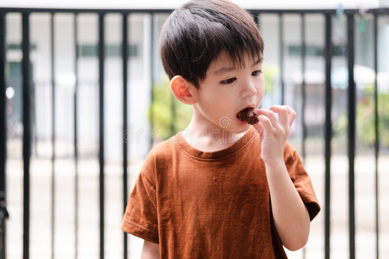 Happy Face of Asian Boy Eating Chocolate Candy Stock Image - Image of ...