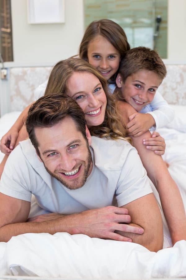 Happy family on the bed stock photo. Image of four, comforter - 51694620