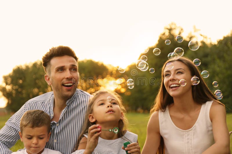 Happy Family Blowing Soap Bubbles in Park at Sunset Stock Image - Image ... Happy Family Blowing Soap Bubbles in Park at Sunset Stock Image - Image ...