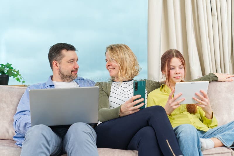 Happy Family on Couch Using Gadget. Rest at Home. Using Digital Devices ...