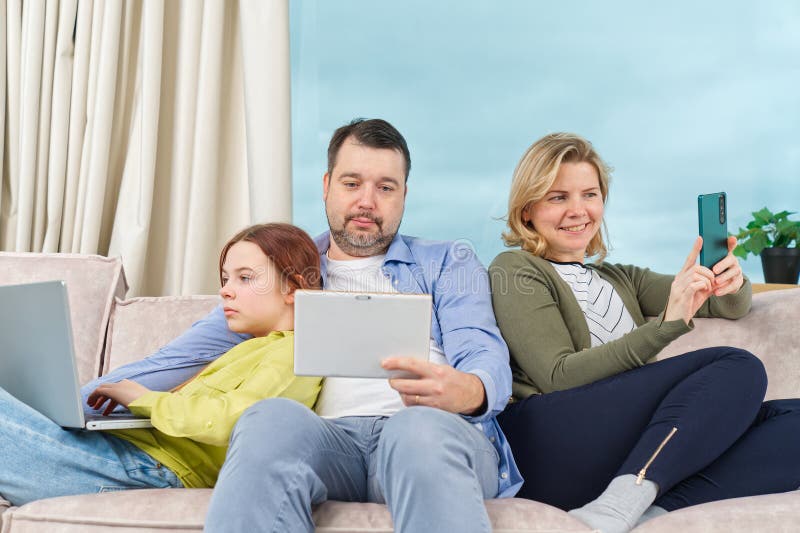 Happy Family on Couch Using Gadget. Rest at Home. Using Digital Devices ...