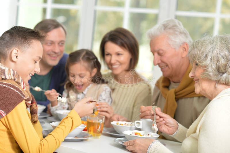 Happy Family of Different Generations Eating Together Stock Photo ...