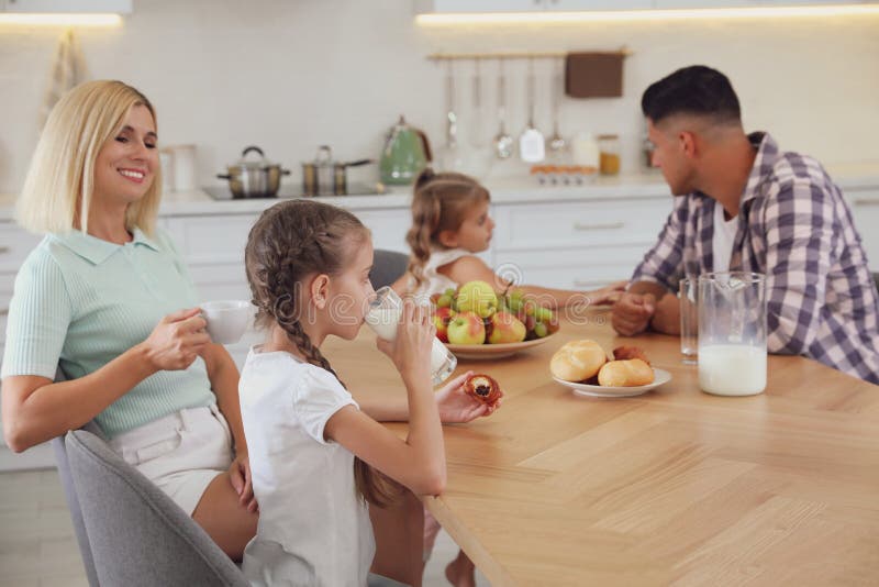 Happy Family Eating Together at Table in Modern Kitchen Stock Image ...
