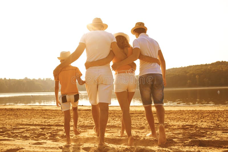 Happy Family Embracing Together on the Beach at Sunset. Stock Photo ...