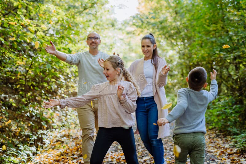 Happy Family Having Fun with a Foliage in Autumn Forest. Stock Image ...