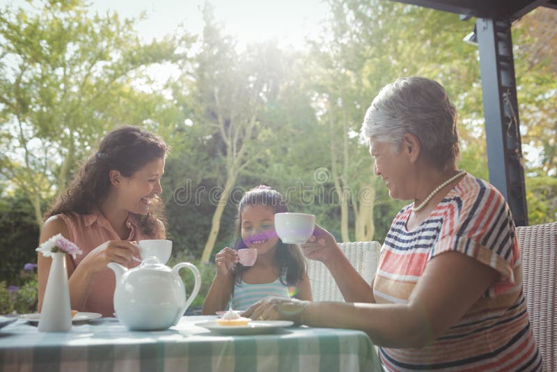 Happy family having tea stock photo. Image of drinking - 94095992
