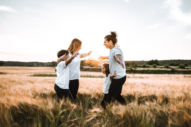 Happy Family Hugging in the Field and Smiling. Family in a Sunset Stock ...