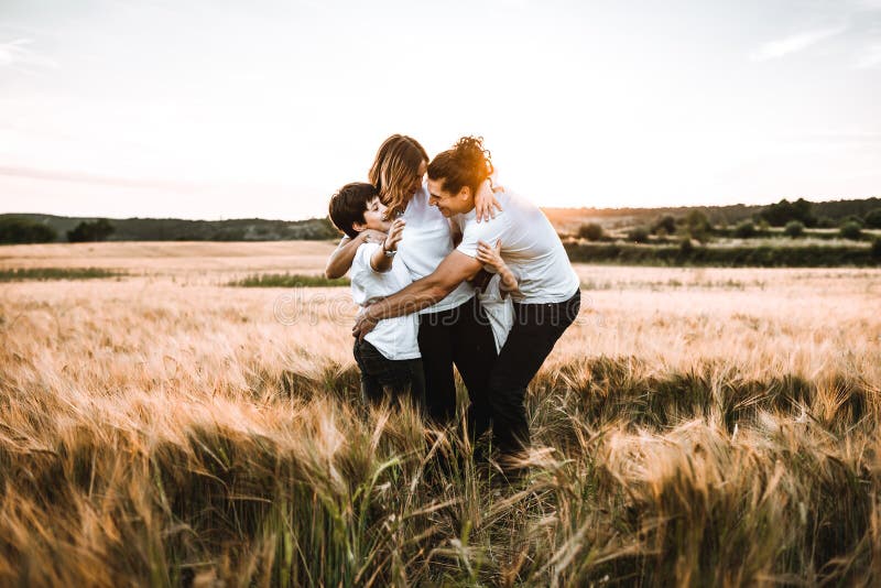 Happy Family Hugging in the Field and Smiling. Family in a Sunset Stock ...