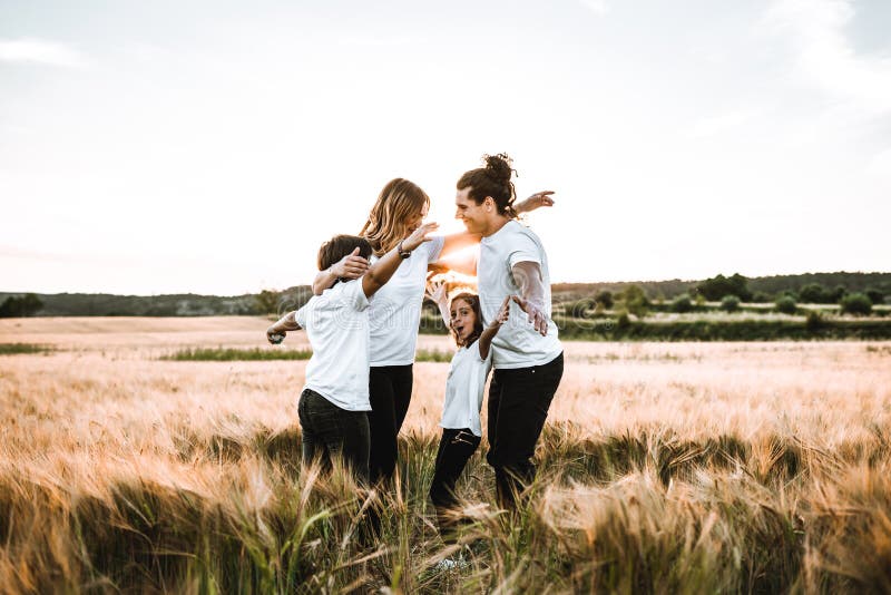 Happy Family Hugging in the Field and Smiling. Family in a Sunset Stock ...