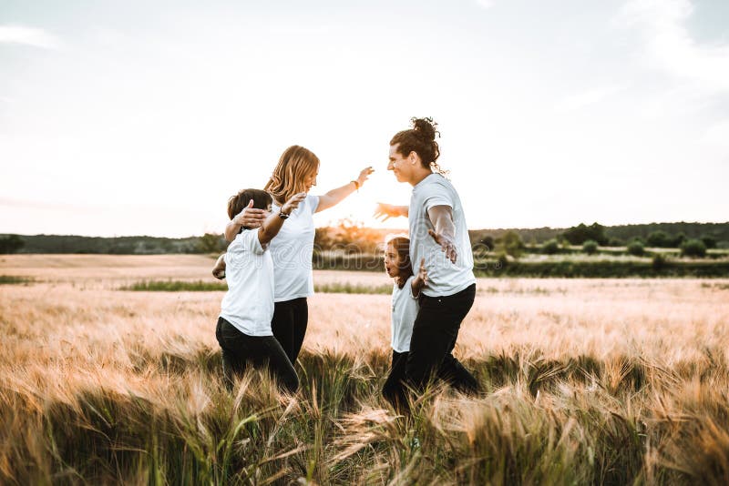 Happy Family Hugging in the Field and Smiling. Family in a Sunset Stock ...