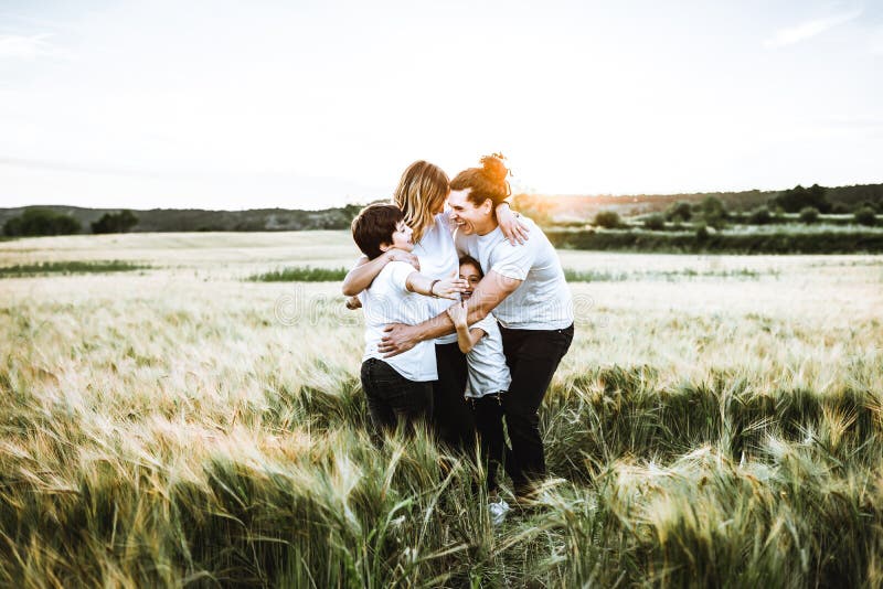 Happy Family Hugging in the Field and Smiling. Family in a Sunset Stock ...