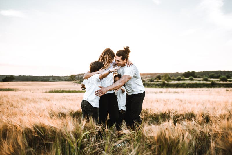 Happy Family Hugging in the Field and Smiling. Family in a Sunset Stock ...