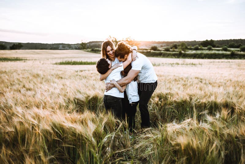 Happy Family Hugging in the Field and Smiling. Family in a Sunset Stock ...
