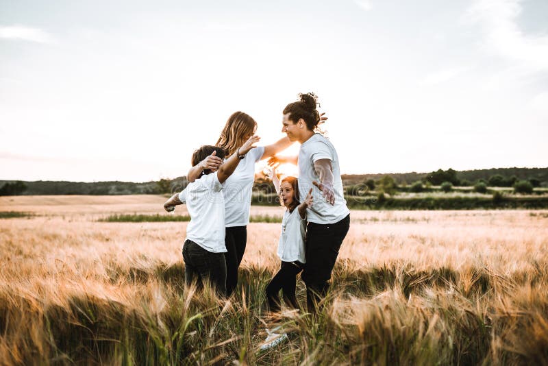 Happy Family Hugging in the Field and Smiling. Family in a Sunset Stock ...