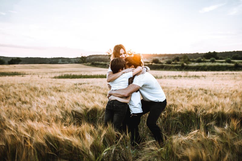 Happy Family Hugging in the Field and Smiling. Family in a Sunset Stock ...