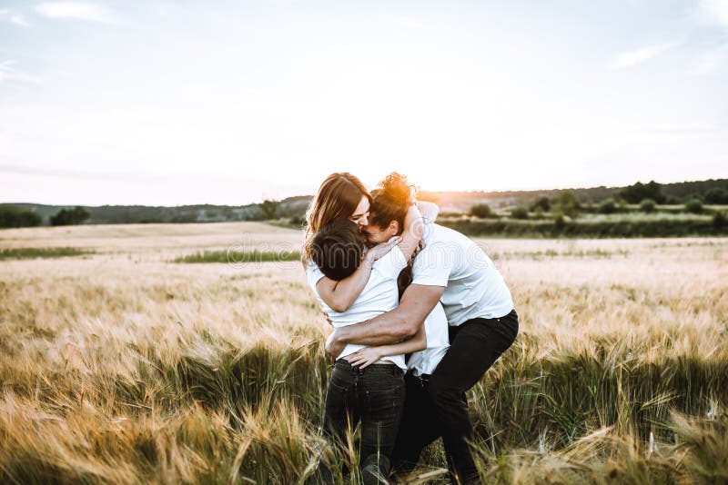 Happy Family Hugging in the Field and Smiling. Family in a Sunset Stock ...