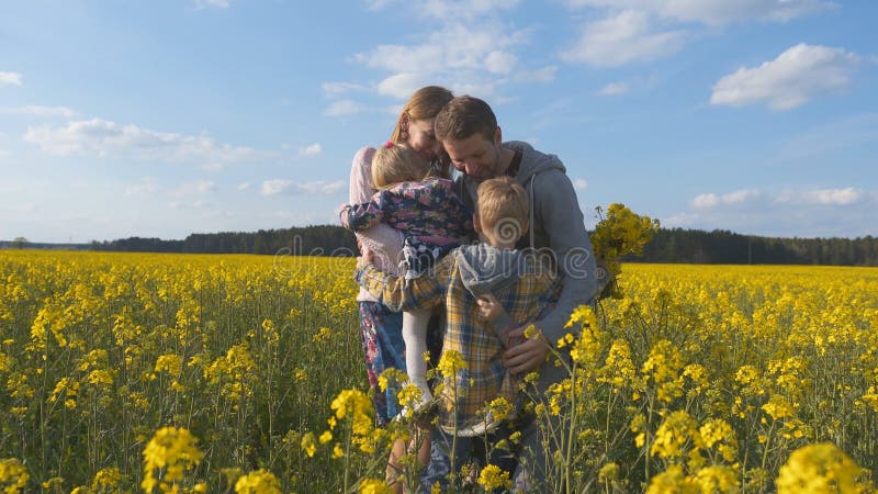 Happy Family Hugs in a Rapeseed Field. Stock Photo - Image of ...