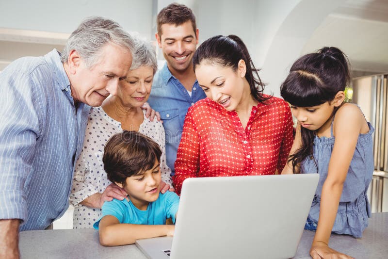 Happy Family Looking at Boy Using Laptop Stock Photo - Image of indoors ...