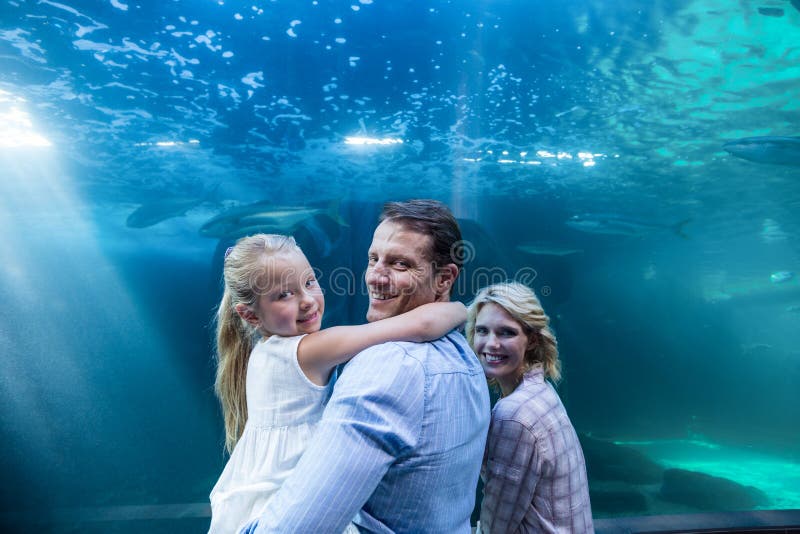 Happy Family Looking at Camera Behind a Fish Tank Stock Image - Image ...