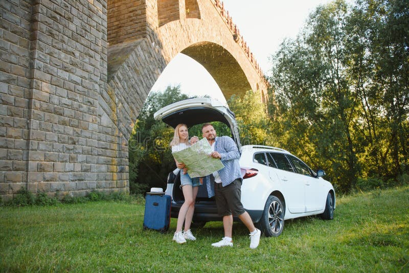 Happy Family Looking at Map Next To Car Stock Photo - Image of couple ...