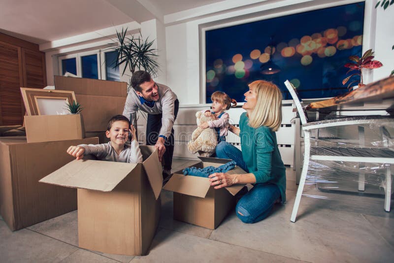 Family Moving Home with Boxes Around, and Having Fun Stock Photo ...